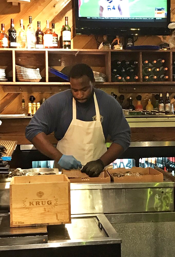 Fresh oysters being shucked with practiced precision. Those hands know exactly what they're doing—creating little oceanic miracles one shell at a time.
