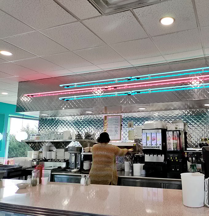 Behind that gleaming stainless steel counter, culinary magic happens under the glow of classic neon lighting—a timeless American ballet.
