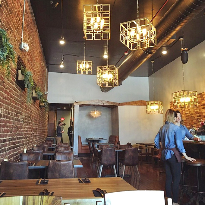 The dining room's warm wood and exposed brick create an atmosphere where conversations flow as easily as the soju.