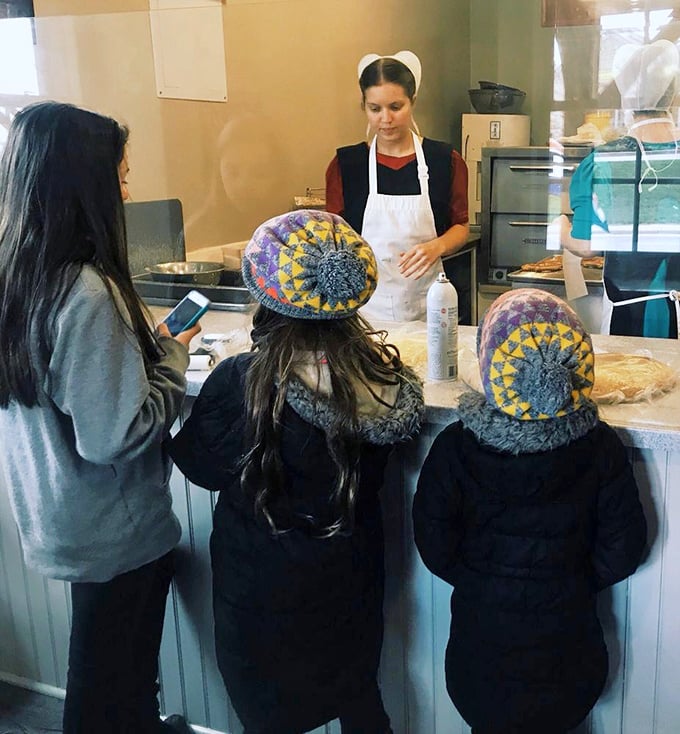 Cultural exchange at its finest—visitors learning the ways of the pretzel from those who know it best.