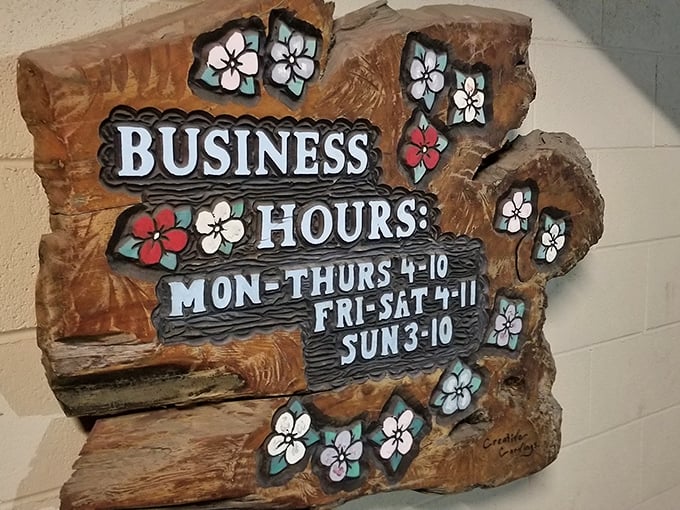 Business hours carved in wood with flower accents—somehow perfectly capturing The Broiler's blend of no-nonsense food with unexpected charm.
