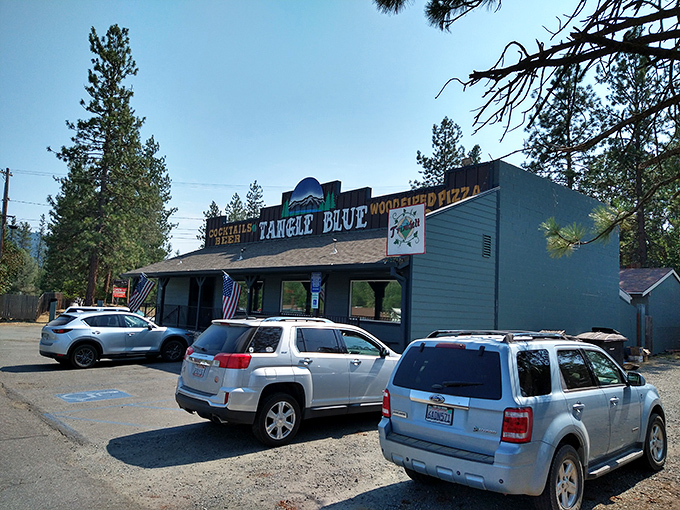 Tangle Blue's rustic exterior promises cold drinks and hot food—the kind of unpretentious spot where both loggers and tourists feel equally welcome.