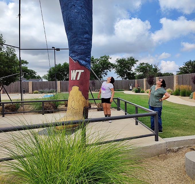Visitors crane their necks in amazement, experiencing that universal moment when human scale meets roadside architectural ambition and wonder ensues.