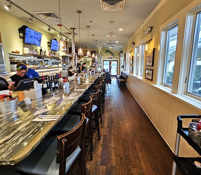 The bar area stretches invitingly, offering front-row seats to both the bartender's craft and the kitchen's culinary choreography.