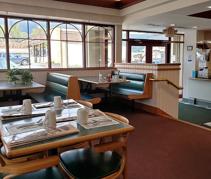Classic booth seating arranged for optimal coffee refill efficiency – these tables have heard more morning confessions than most therapists.