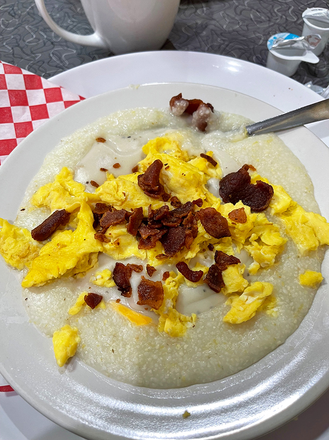 Grits topped with scrambled eggs and bacon bits – a Southern breakfast trinity that proves simplicity is often the highest form of culinary art.