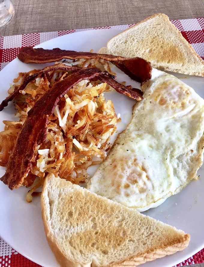 Breakfast doesn't get more classic than this: eggs, hash browns, bacon, and toast—the morning quartet performing their greatest hits on a white plate.