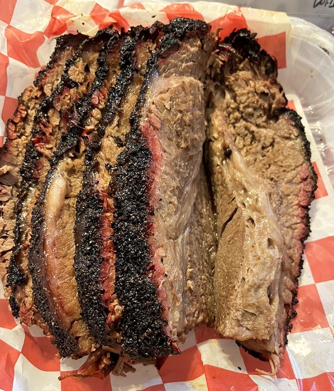 Brisket sliced so perfectly it could make a grown Texan weep. That smoke ring isn't just good—it's frame-worthy.
