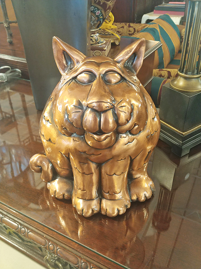 This golden cat figurine isn't just decor—it's the guardian of good taste, judging your other purchases with its perpetually amused expression.