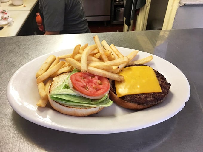 Cheeseburger simplicity at its finest – hand-formed patty, melty American cheese, fresh veggies, and a side of fries that didn't come from a freezer.