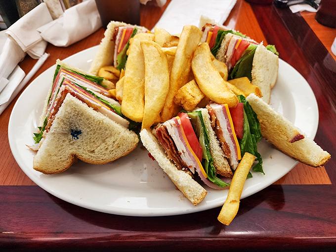 This club sandwich stands tall and proud, layers stacked with military precision—a skyscraper of flavor that requires both hands and a strategy.