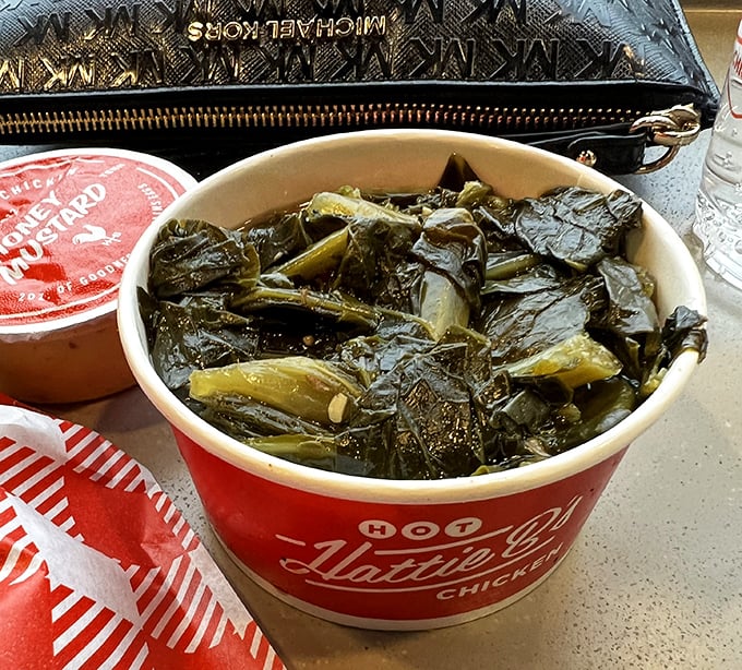 These aren't just collard greens—they're the soul-soothing Southern counterpoint to all that chicken bravado, cooked low and slow with proper respect.