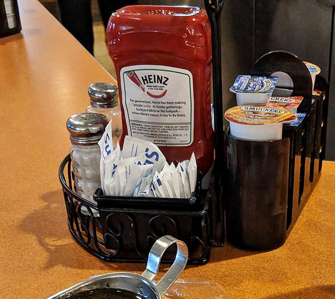 The condiment caddy—civilization's greatest achievement. Salt, pepper, ketchup, and sugar packets: the four food groups of diner dining.