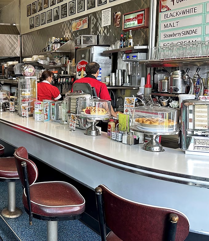 The counter seats—where solo diners become regulars and regulars become family. Chrome and vinyl never looked so inviting.