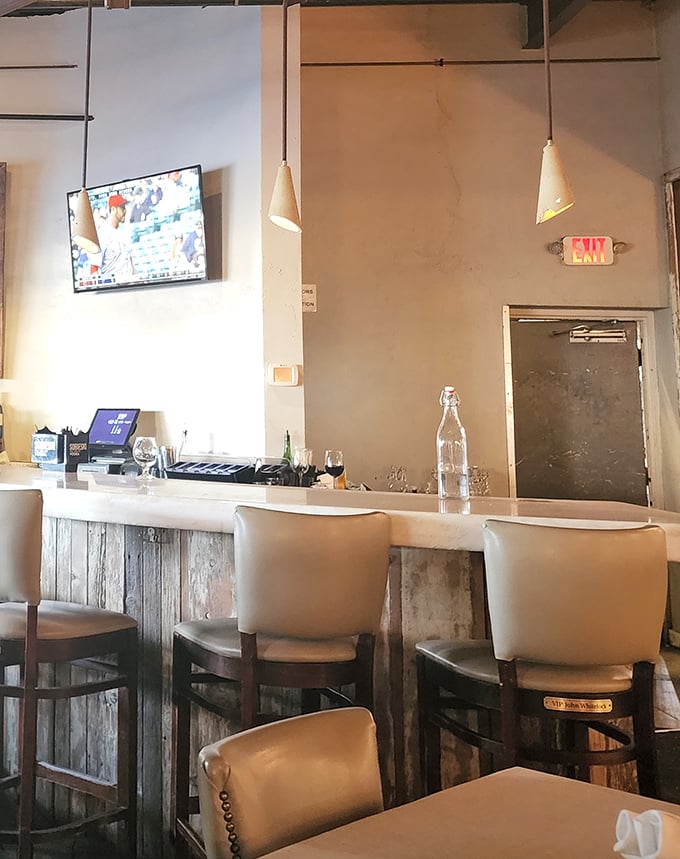 The bar seating offers front-row tickets to the mixology show – where casual conversations with strangers often become the unexpected highlight of your evening.