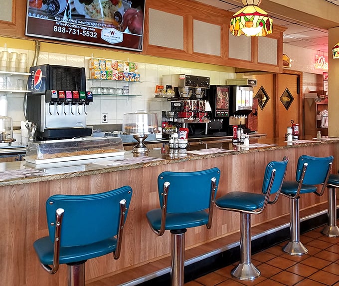 The counter with its blue swivel chairs—where solo diners find community and the coffee never stops flowing. Diner diplomacy at its finest.