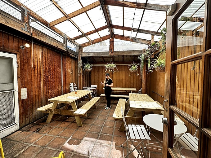 The covered patio offers a perfect California dining experience—casual wooden benches under a translucent roof that captures natural light.