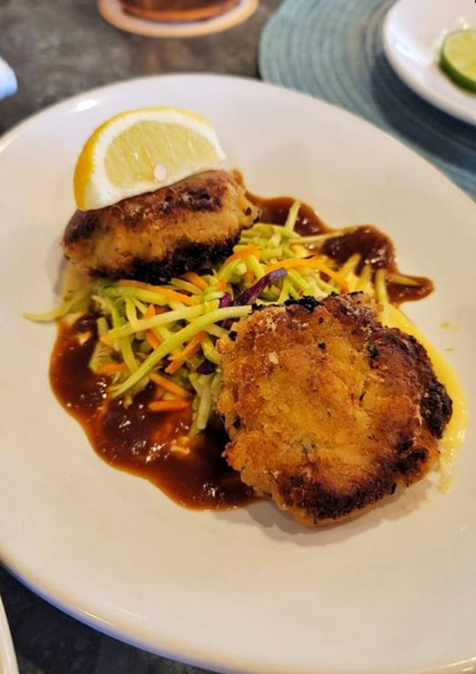 These crab cakes aren't just browned—they're caramelized to perfection. Sitting atop that vibrant slaw, they're the superheroes of the seafood world.