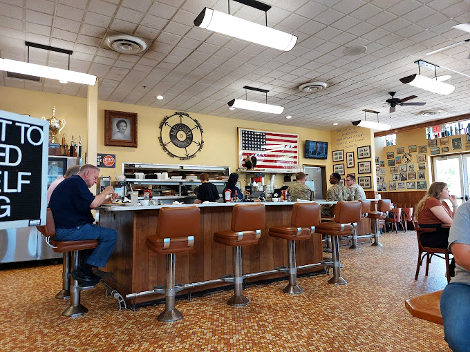The counter seating—where solo diners become temporary family and the staff remembers your order before you've fully settled onto your stool.