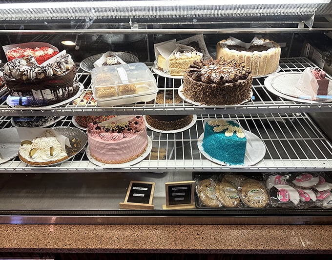 A dessert case that makes willpower crumble faster than their apple pie crust. Each cake stands proud, silently daring you to say "I'll just have a bite."