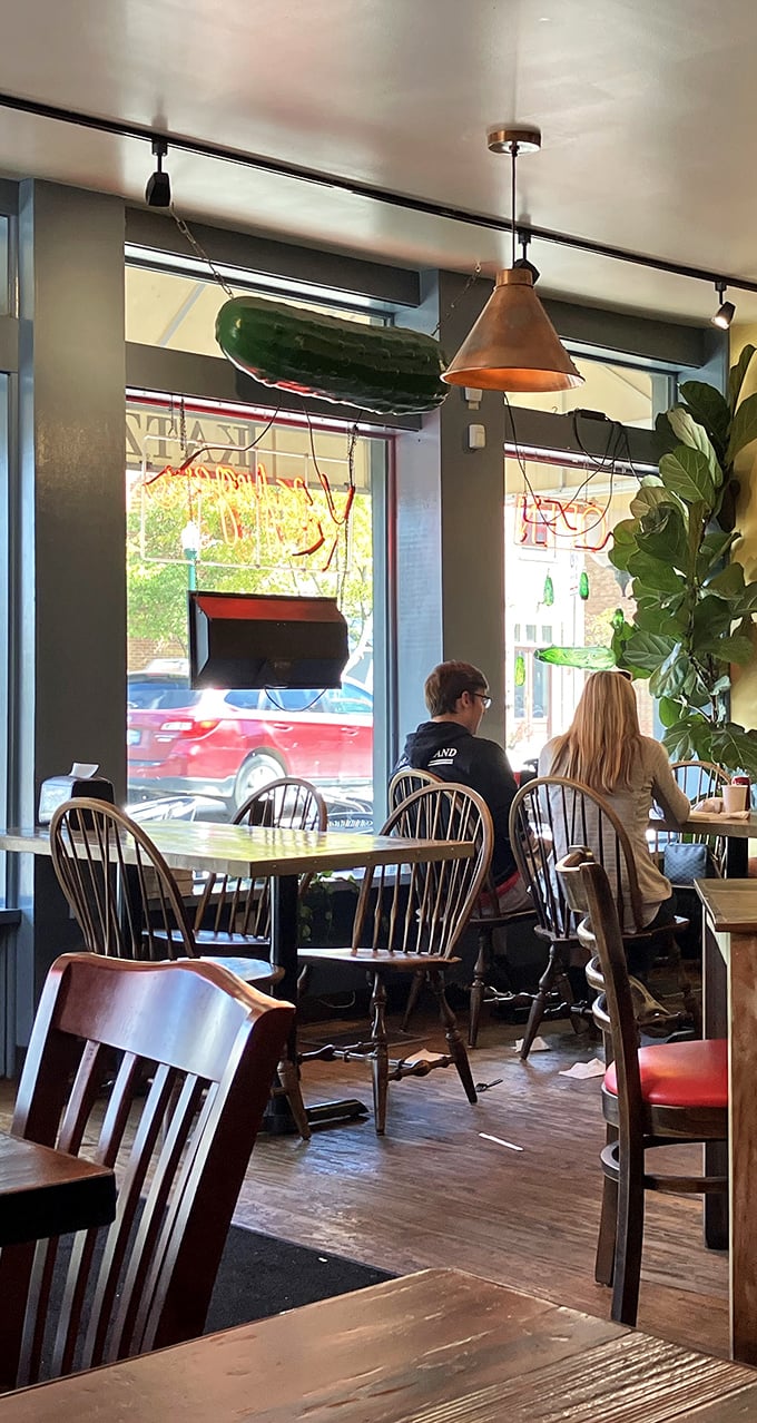 That giant pickle hanging from the ceiling isn't just decoration – it's a green guardian angel watching over your meal.
