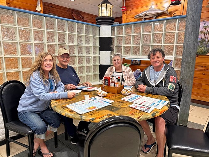 Happy diners gathered around a lighthouse-themed table – the universal expression of "we ordered exactly right" on every face.