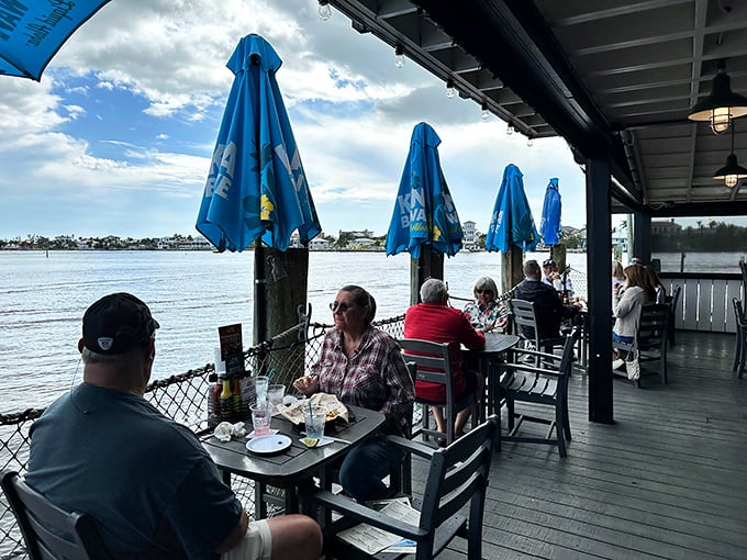 Happy diners enjoying fresh catches while boats drift by – this is Florida living at its finest.