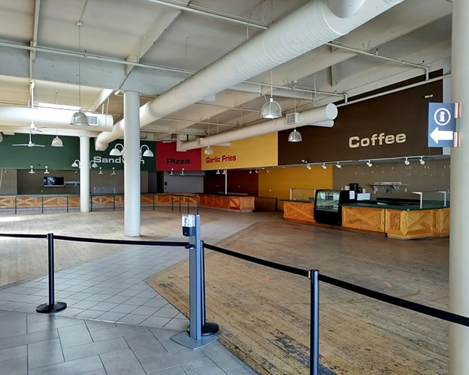 The food court stands ready for retail warriors needing refueling—note the "Garlic Fries" sign, a delicious reminder you're in Gilroy, California's garlic capital.