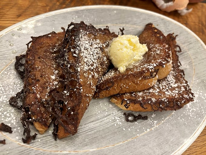 French toast that's clearly been working out—thick-cut, caramelized edges, and a dollop of butter slowly surrendering to the warmth.