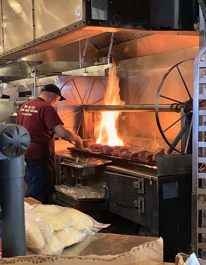 The open flames tell the real story – where pitmasters work their magic over glowing coals and dreams.