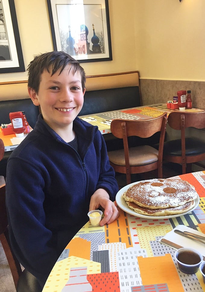 The universal expression of pancake joy – powdered sugar dusted flapjacks that make smartphones temporarily irrelevant.