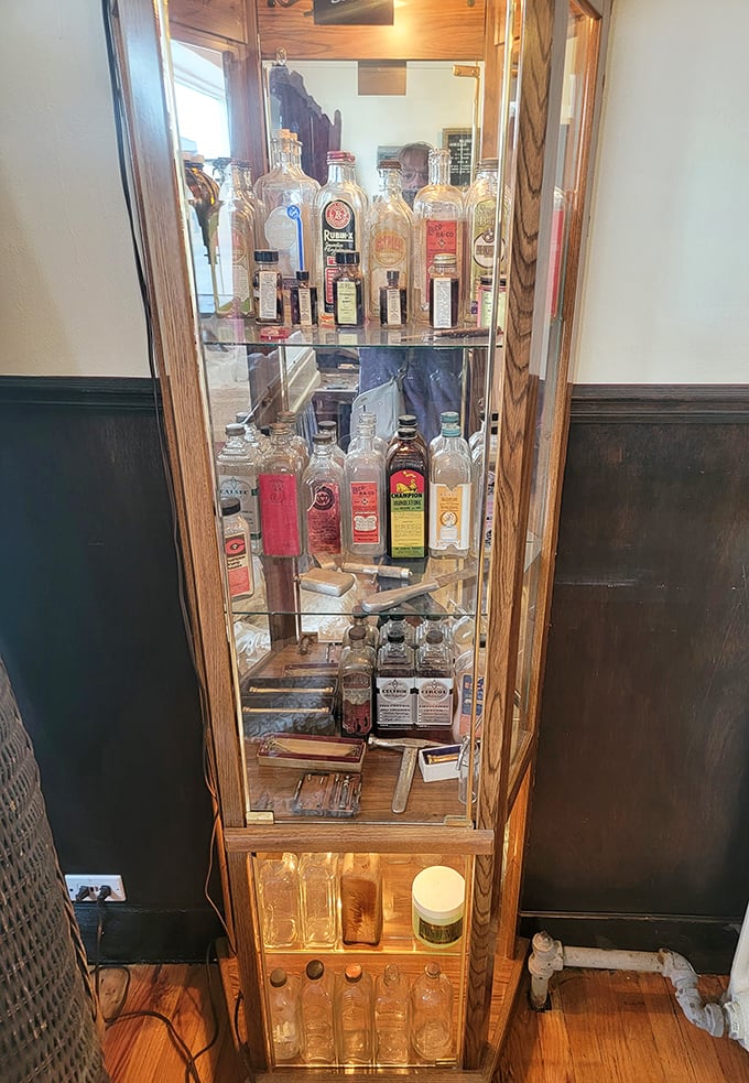 Antique medical and embalming bottles displayed in a vintage cabinet—remedies and preparations from a less regulated era.