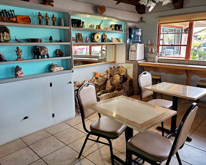 Turquoise shelves display cultural treasures while diners enjoy their meals. It's like eating in a museum where the art enhances the flavor of every bite.