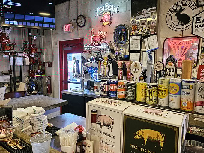 The wall of fame showcases beer signs and barbecue accolades—a museum of good times where neon glows like smoky halos.