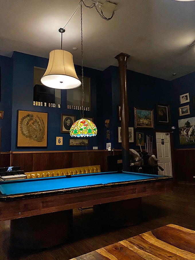 The pool table bathed in blue light under a Tiffany-style lamp creates the perfect "should we play a game or order another round?" dilemma.