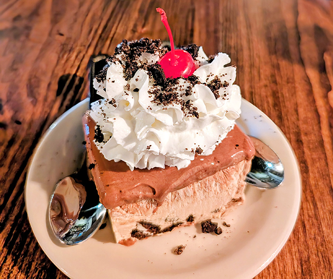 This isn't just chocolate pie—it's a towering achievement of cream, cookie crumbles, and that perfectly positioned cherry on top.