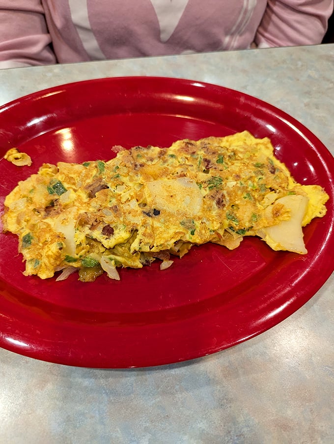 An omelet that's achieved perfect balance—fluffy eggs cradling a medley of fillings in a display of breakfast engineering.