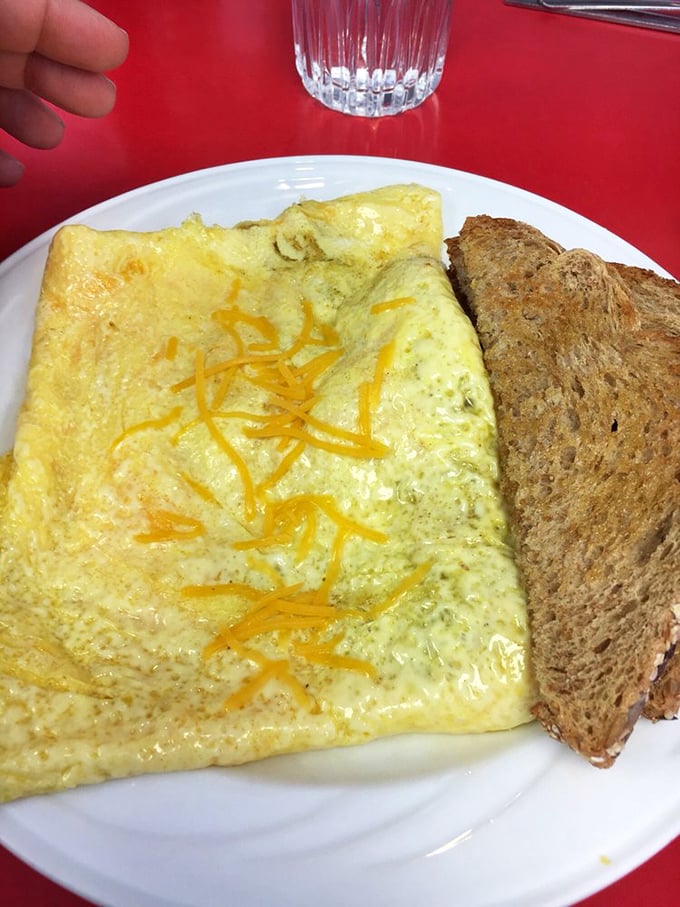 This isn't just an omelet—it's a fluffy yellow envelope delivering a cheesy message directly to your taste buds, with toast standing by for dipping duty.
