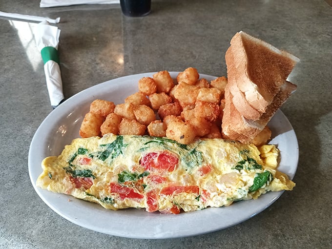 A vegetable omelet that proves eggs can be both breakfast and vegetable delivery system. Those golden tots are no mere sidekick.