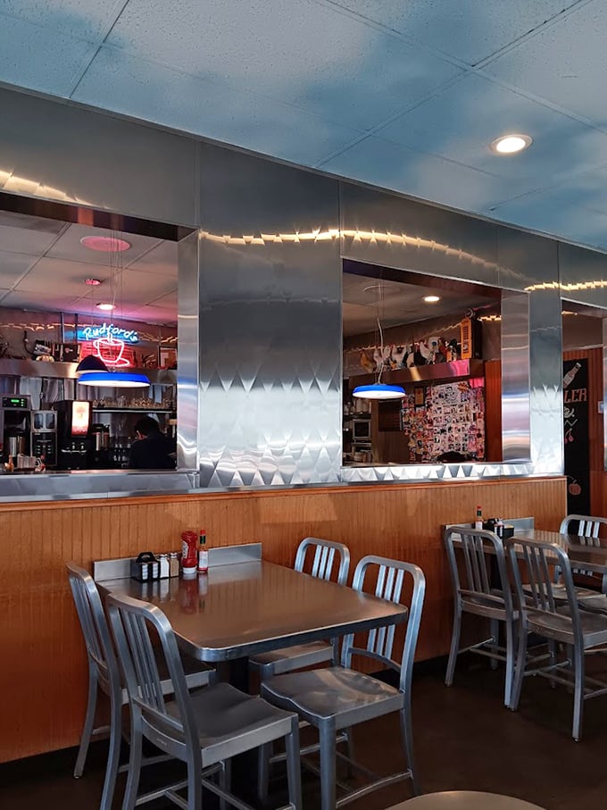 Metal chairs, wood paneling, and the soft glow of neon—not designed by an Instagram influencer, but authentically lived-in and loved.