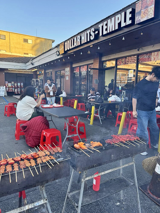 The outdoor grill scene is where the magic happens – skewers sizzling while diners perch on red stools like they've discovered the world's best-kept secret.