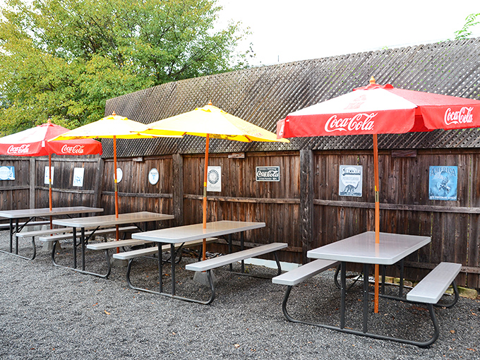 The outdoor seating area – where picnic tables under Coca-Cola umbrellas create that perfect summer vibe for enjoying sauce-slathered ribs without judgment.