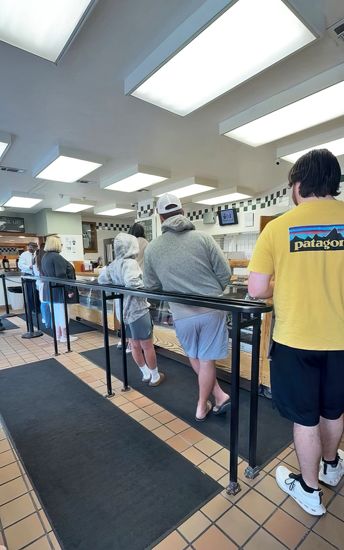 The pilgrimage line—where patience is tested but always rewarded. Notice the diverse crowd united by a common quest for fried perfection.