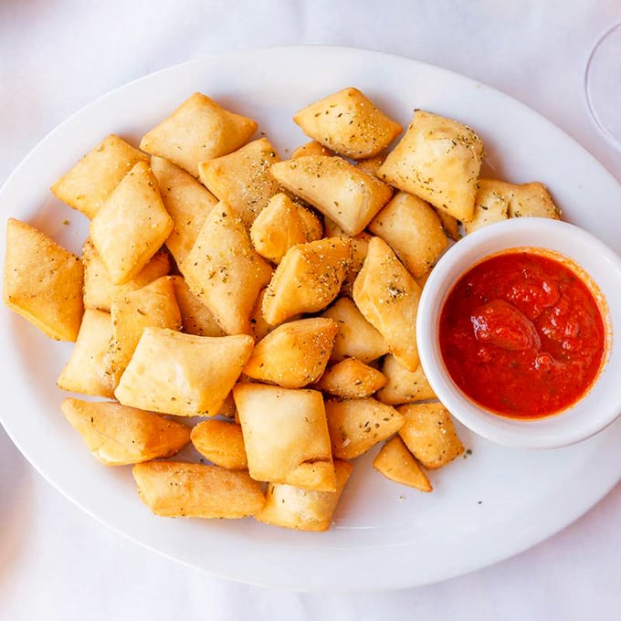 These golden pillows of dough aren't just appetizers—they're little rectangles of joy, served with marinara that should be bottled and sold as therapy.