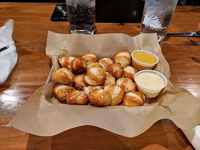 These pretzel bites arrive like golden pillows of joy, accompanied by dipping sauces that elevate snacking to an art form.