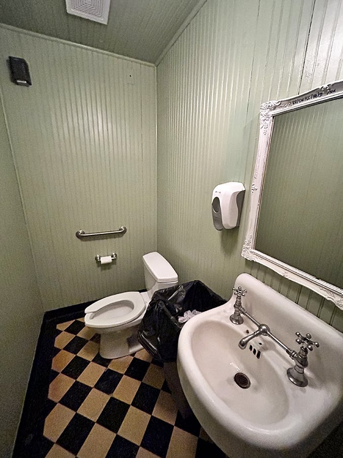 Even the bathroom has character—mint green walls and checkerboard floors that feel like stepping into your stylish great-aunt's 1950s powder room.