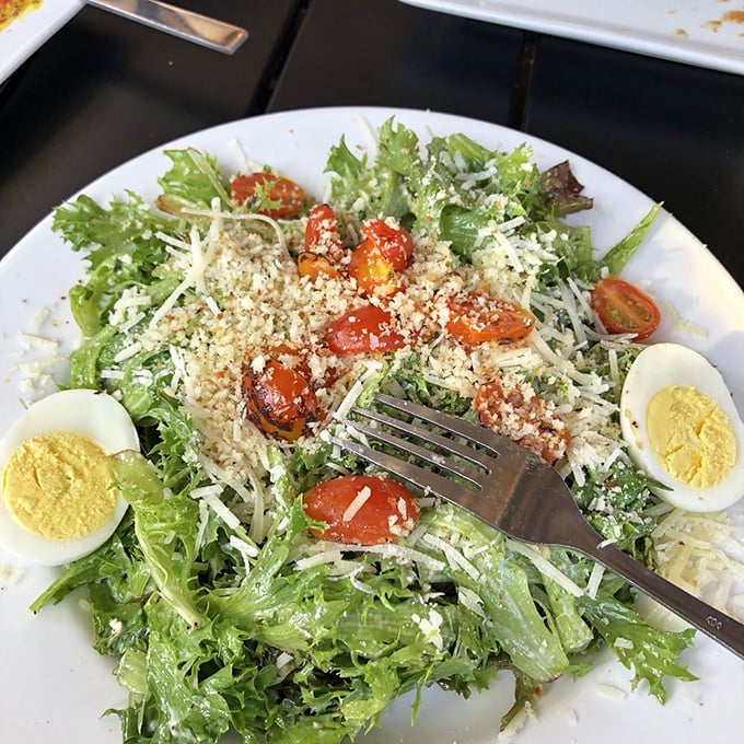 A Caesar salad that actually deserves the name—fresh greens, proper dressing, and enough parmesan to remind you that vegetables can be exciting.