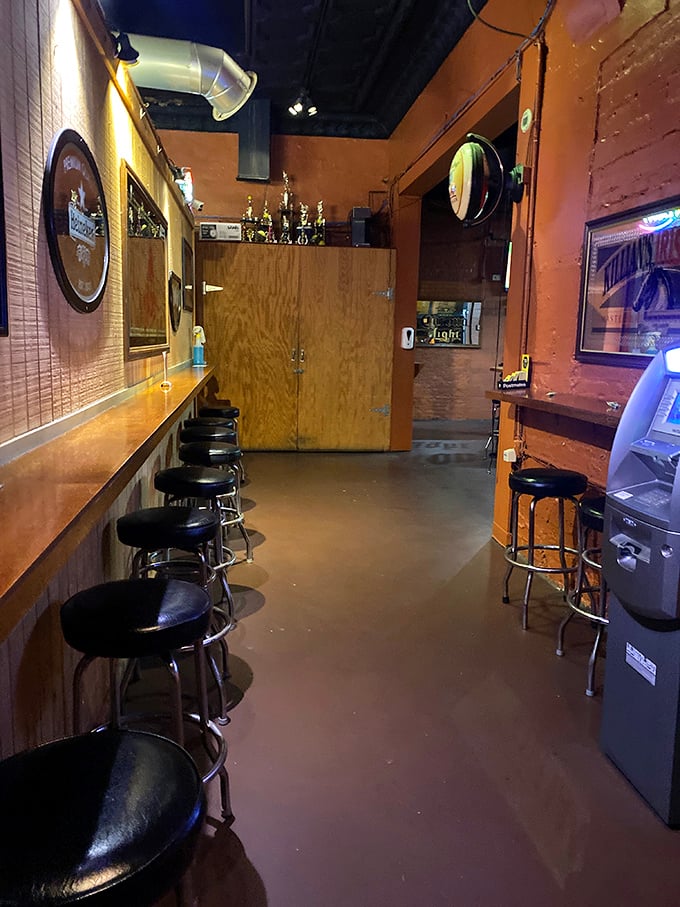A narrow hallway lined with bar stools—the kind of intimate space where strangers become friends over shared pizza recommendations.