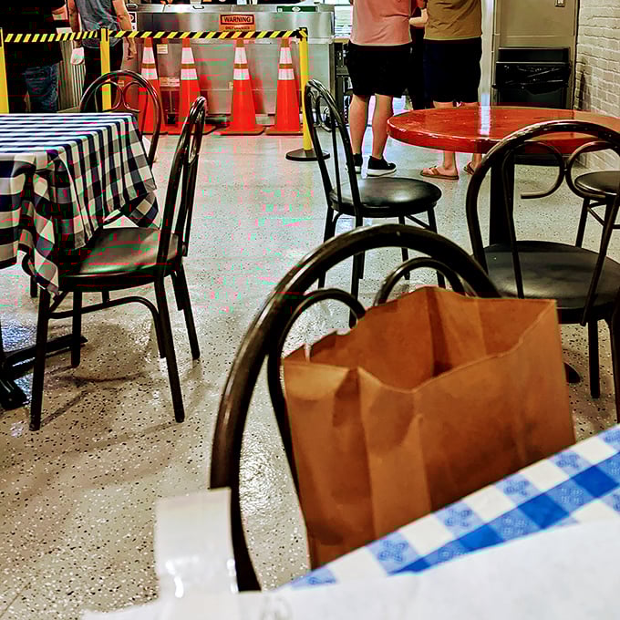 Indoor seating with checkered tablecloths – where construction workers and office folks unite over sandwich appreciation.
