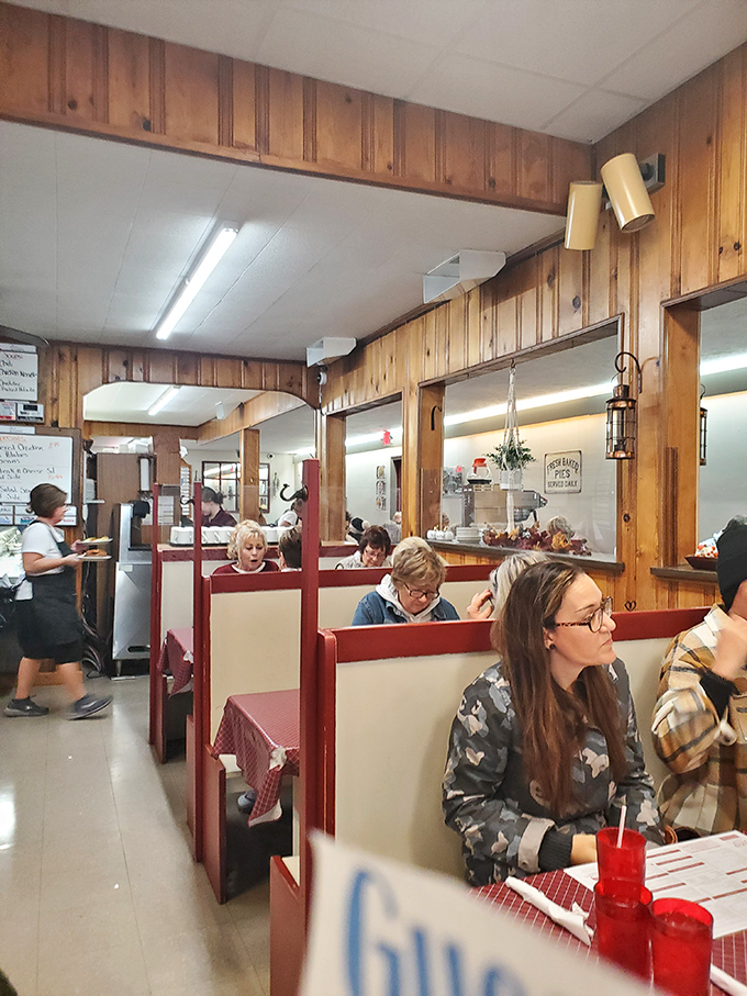 Red-trimmed booths create little islands of conversation—where strangers become friends over shared appreciation of gravy and homemade pie.